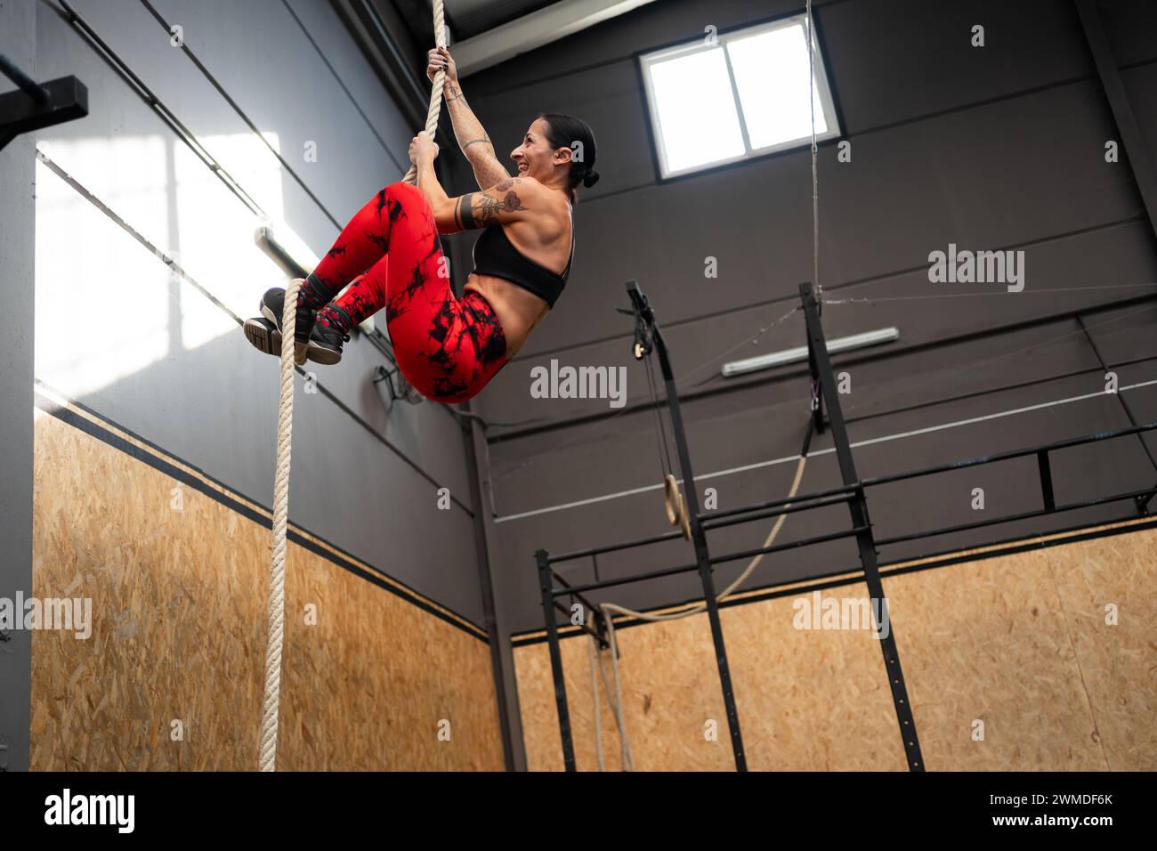 Muscular woman climbing rope hi-res stock photography and images - Alamy