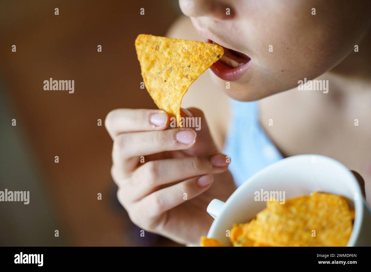 Unrecognizable teenage girl eating delicious Mexican nacho chip Stock ...