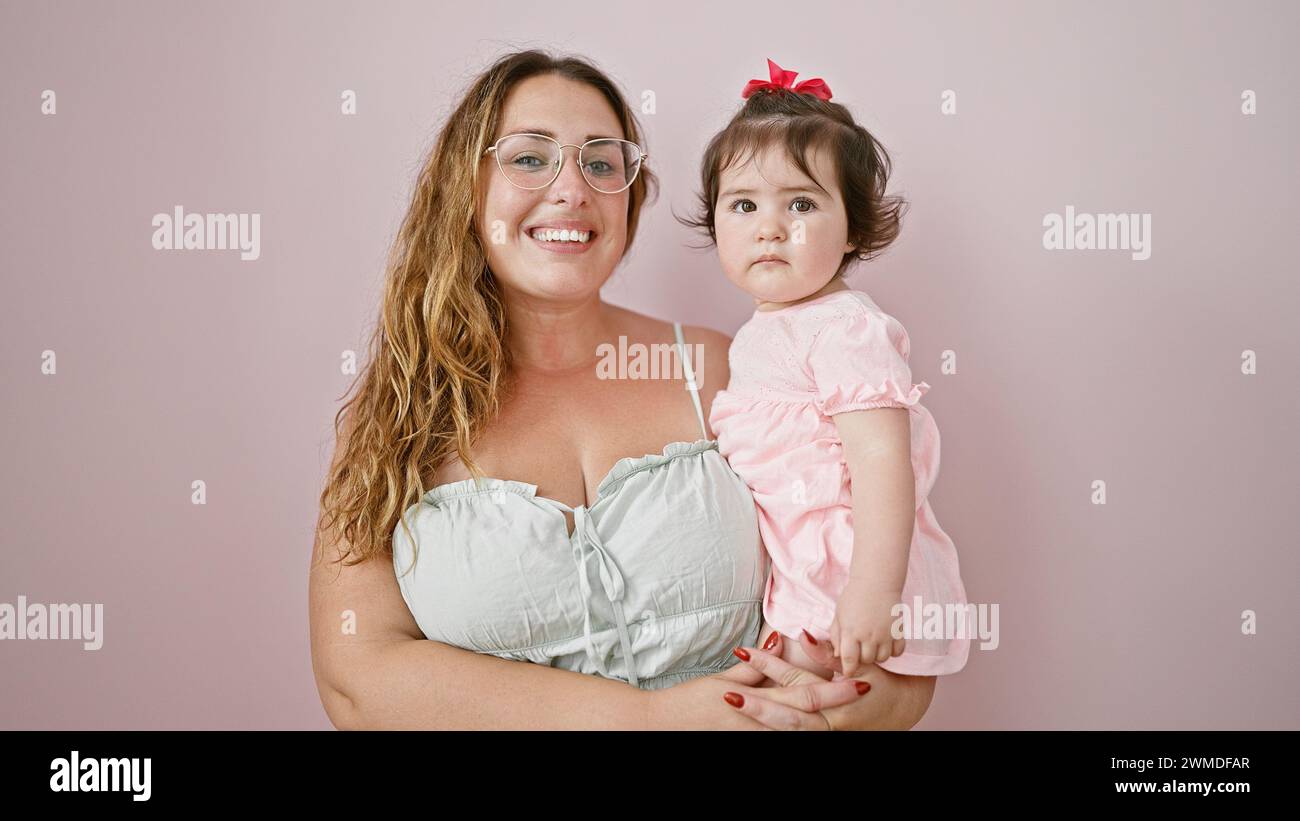 Confident mother joyfully holding her cute baby daughter in her arms ...