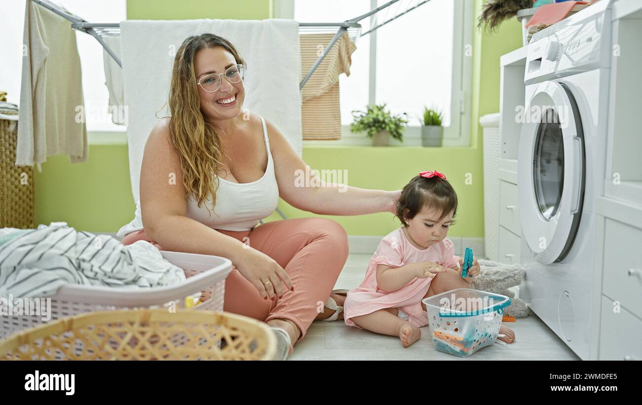 Mother and daughter share a smile while enjoying laundry time together at home Stock Photo - Alamy
