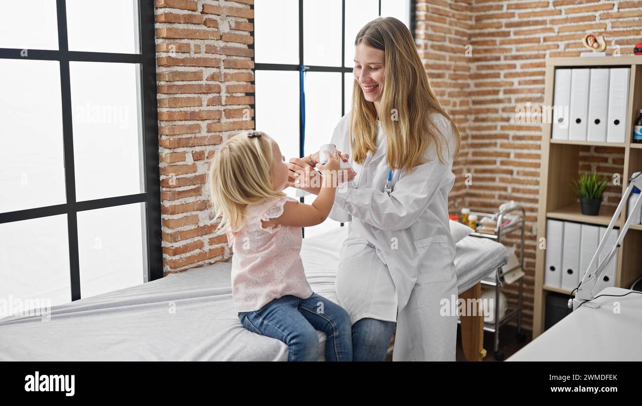 Caring pediatric doctor and adorable little girl patient playfully ...