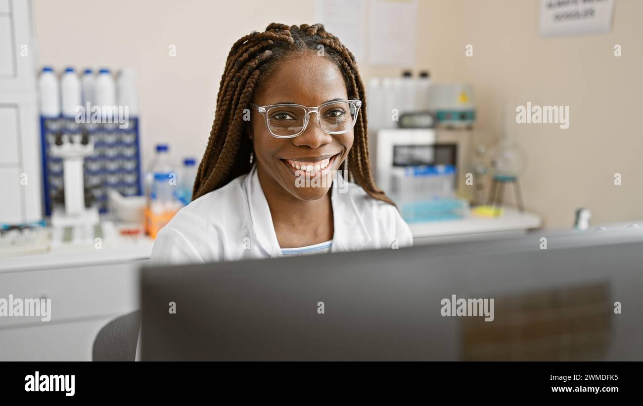Portrait of a smiling african american woman with braids wearing lab ...
