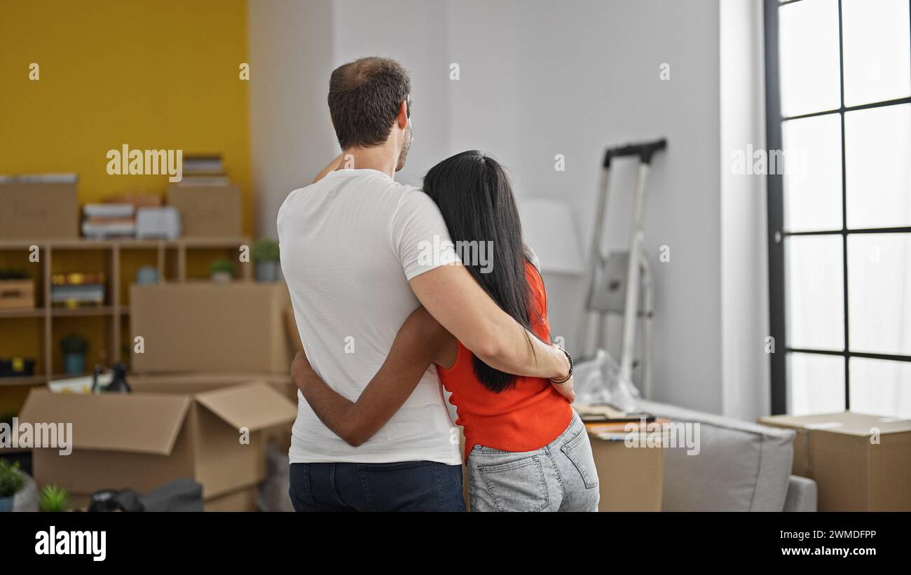 Beautiful couple standing backwards hugging each other at new home ...