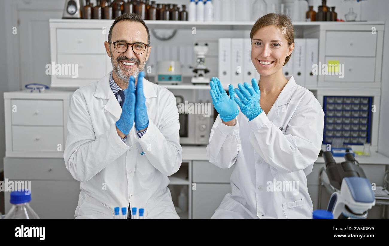Two smiling scientists clapping hands in applause, celebrating major ...