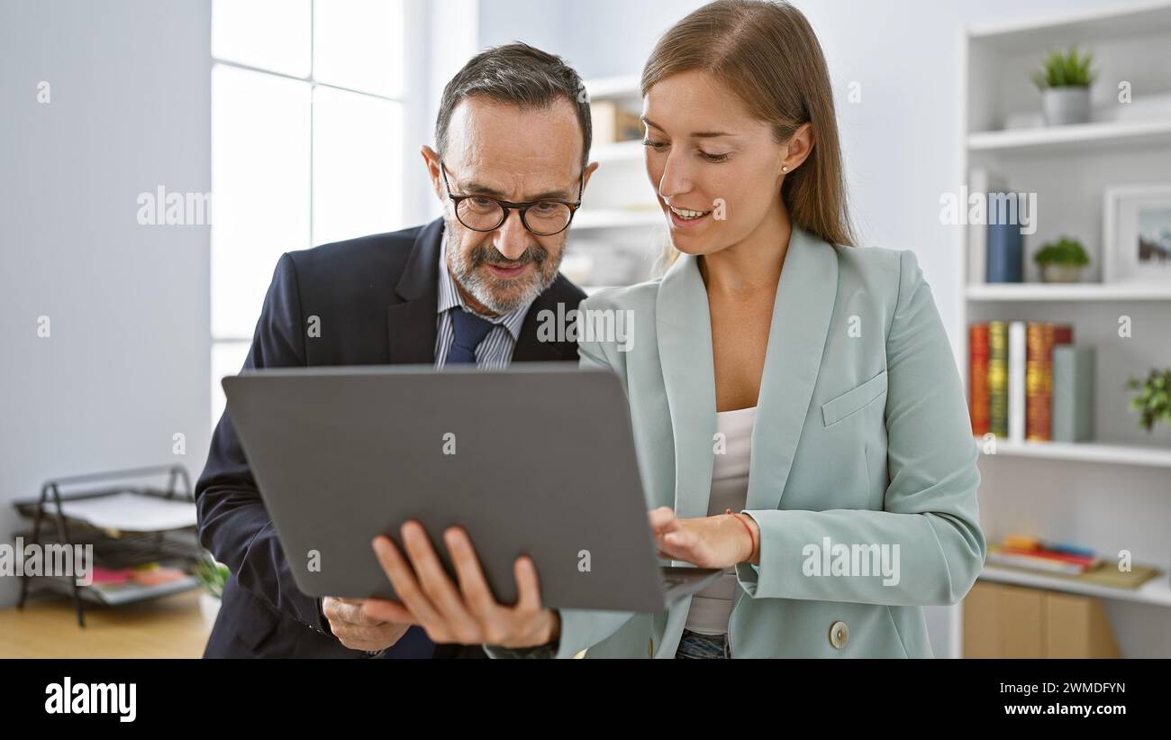 Two confident business workers smiling as they work together on a ...
