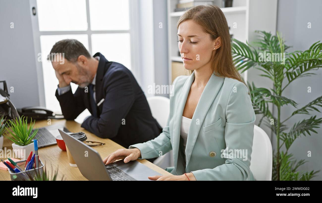 Two serious-faced business workers engrossed in successful work at a ...