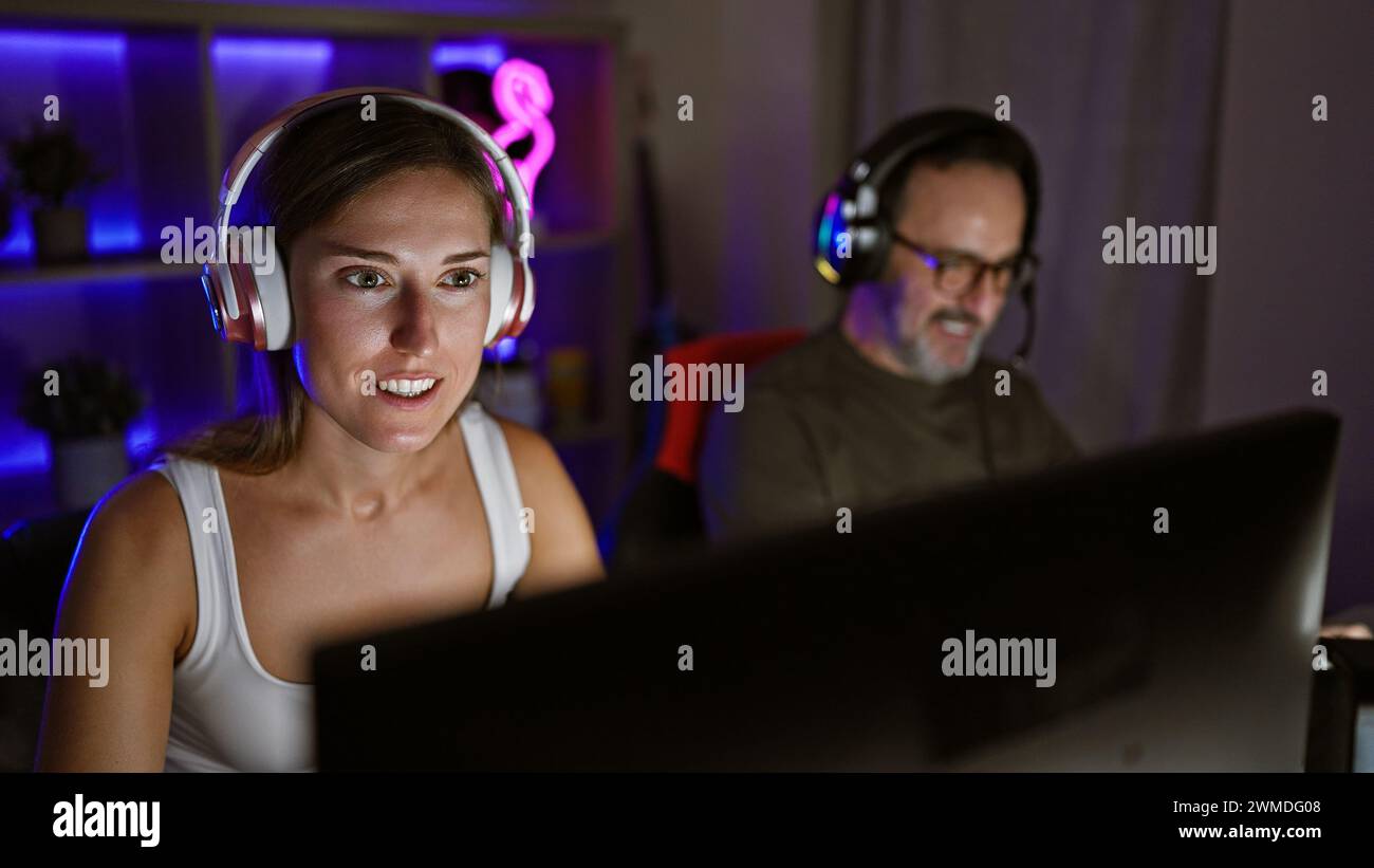 Father and daughter together in gaming glory, two smiling gamers revel ...