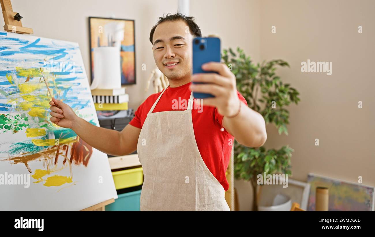 Confident young chinese artist, wearing an apricot apron, gleefully ...