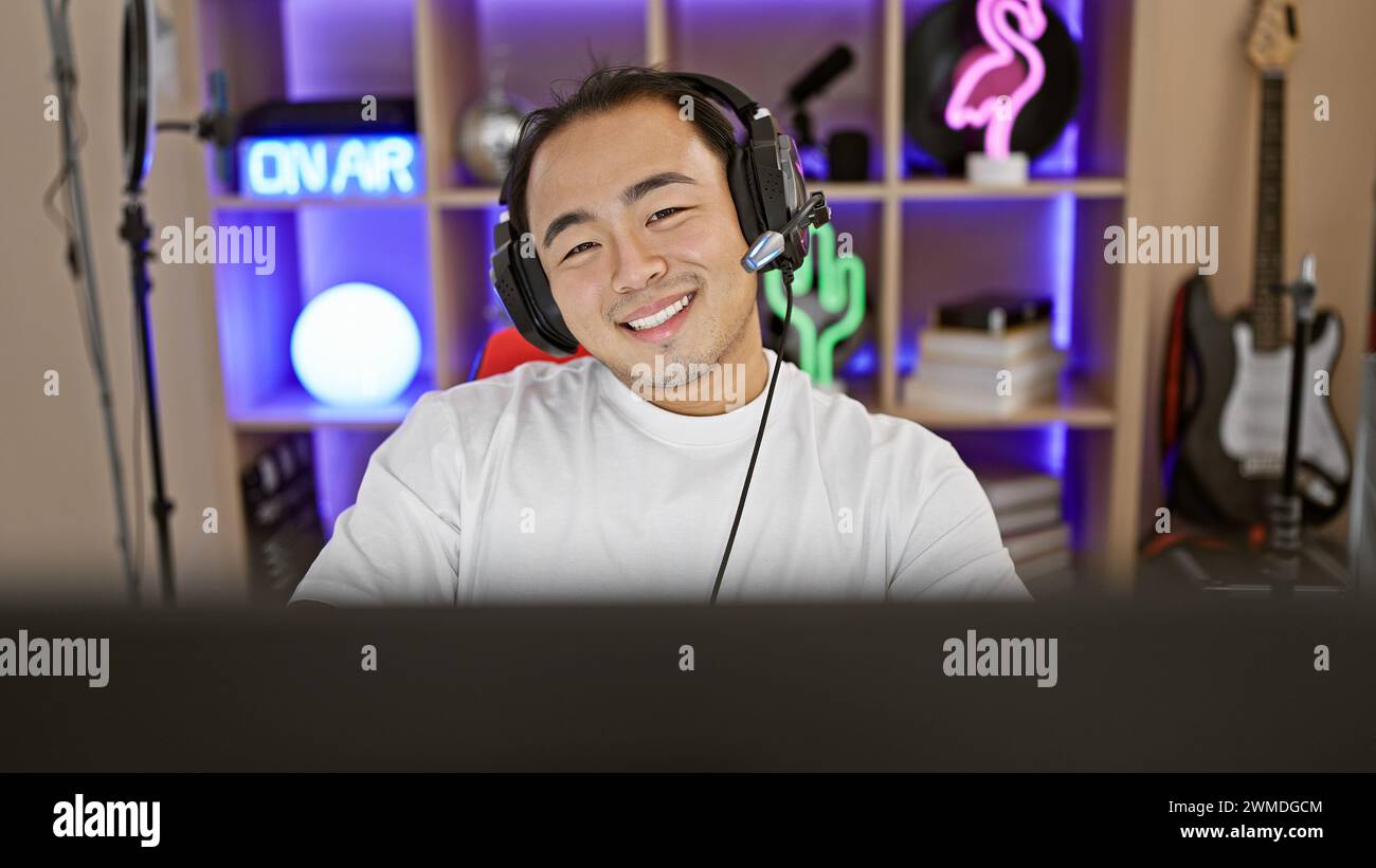 Confident young chinese man, a digital gamer streamer, smiling with ...