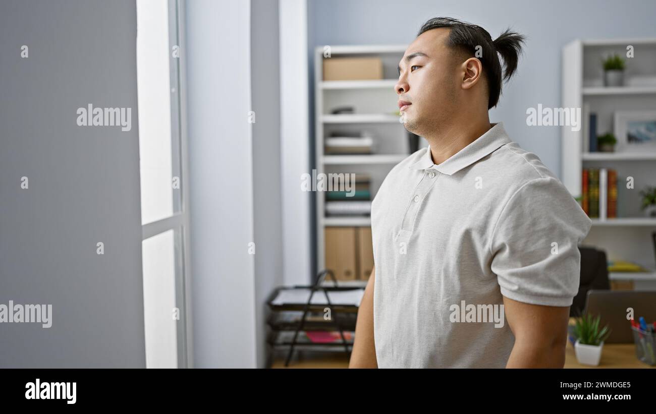 Young, handsome chinese business worker in pigtails looking through the ...