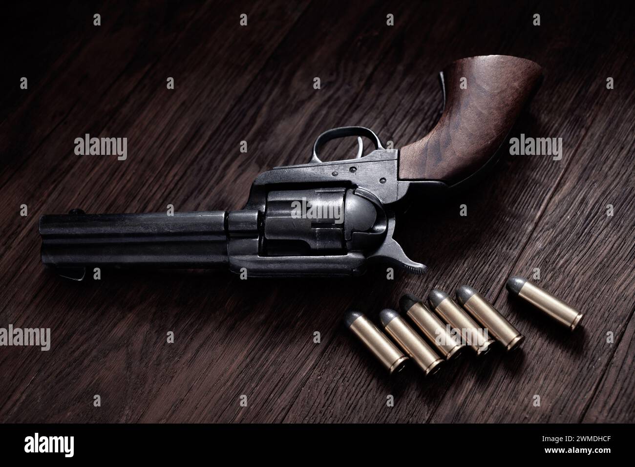 Old west 45 caliber peacemaker revolver with cartridges on wooden table ...