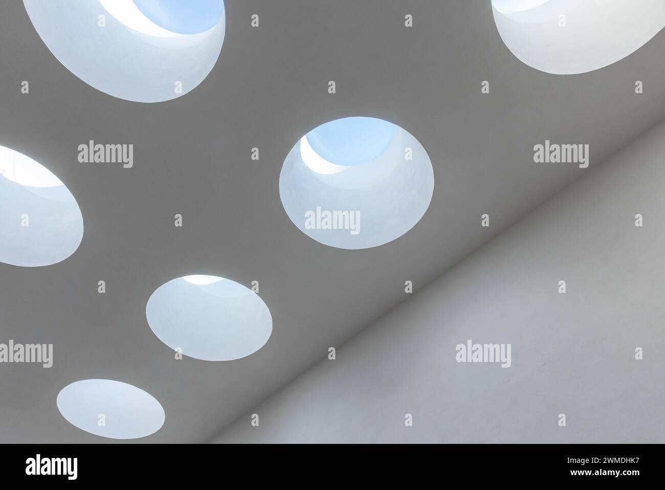 Round ceiling skylight portals with blue sky behind in a white room ...