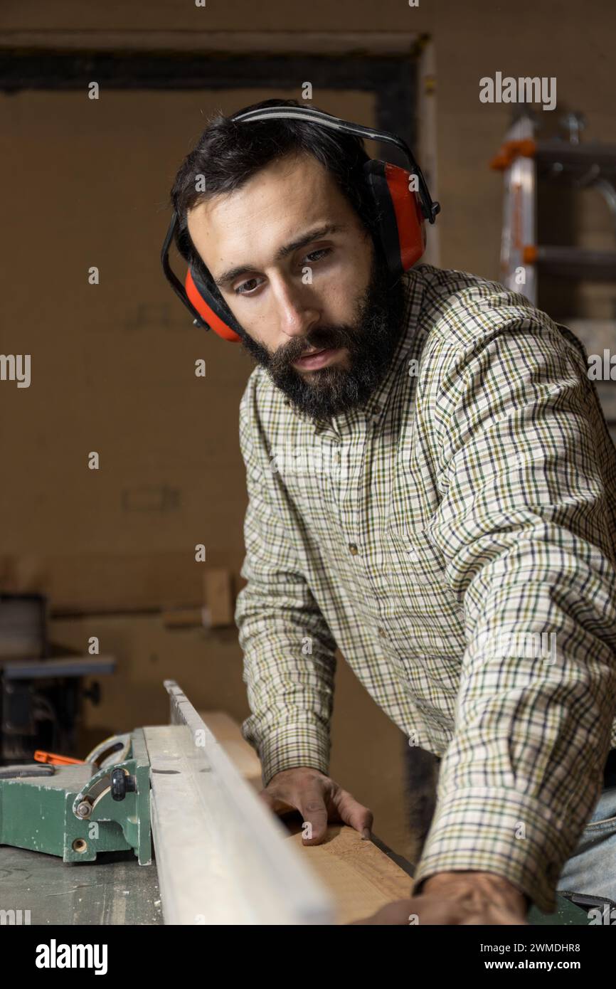 Vertical photo engrossed in his work, a carpenter man mid adult ...