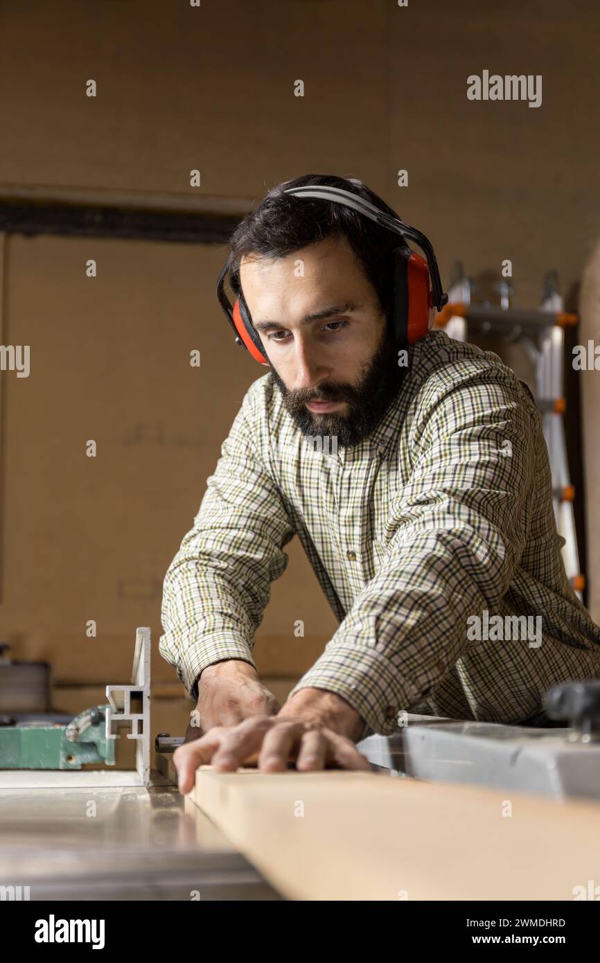 Vertical photo Captured from a dynamic angle, a man mid adult carpenter ...