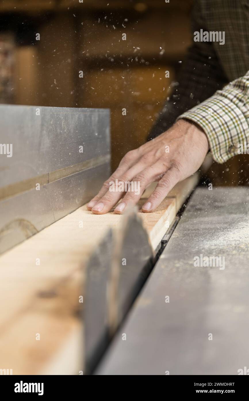 Vertical photo in the midst of sawing, a carpenter's hands expertly ...