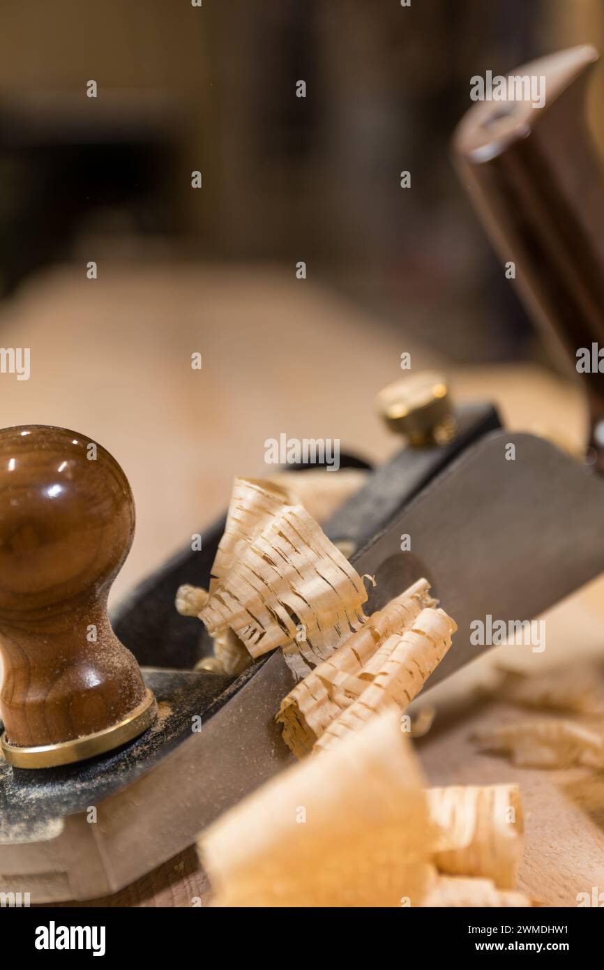 Vertical photo a woodworker's hand plane rests amidst curling shavings ...