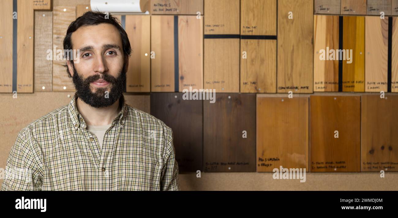 Horizontal photo a confident woodworker stands before a wall of labeled ...