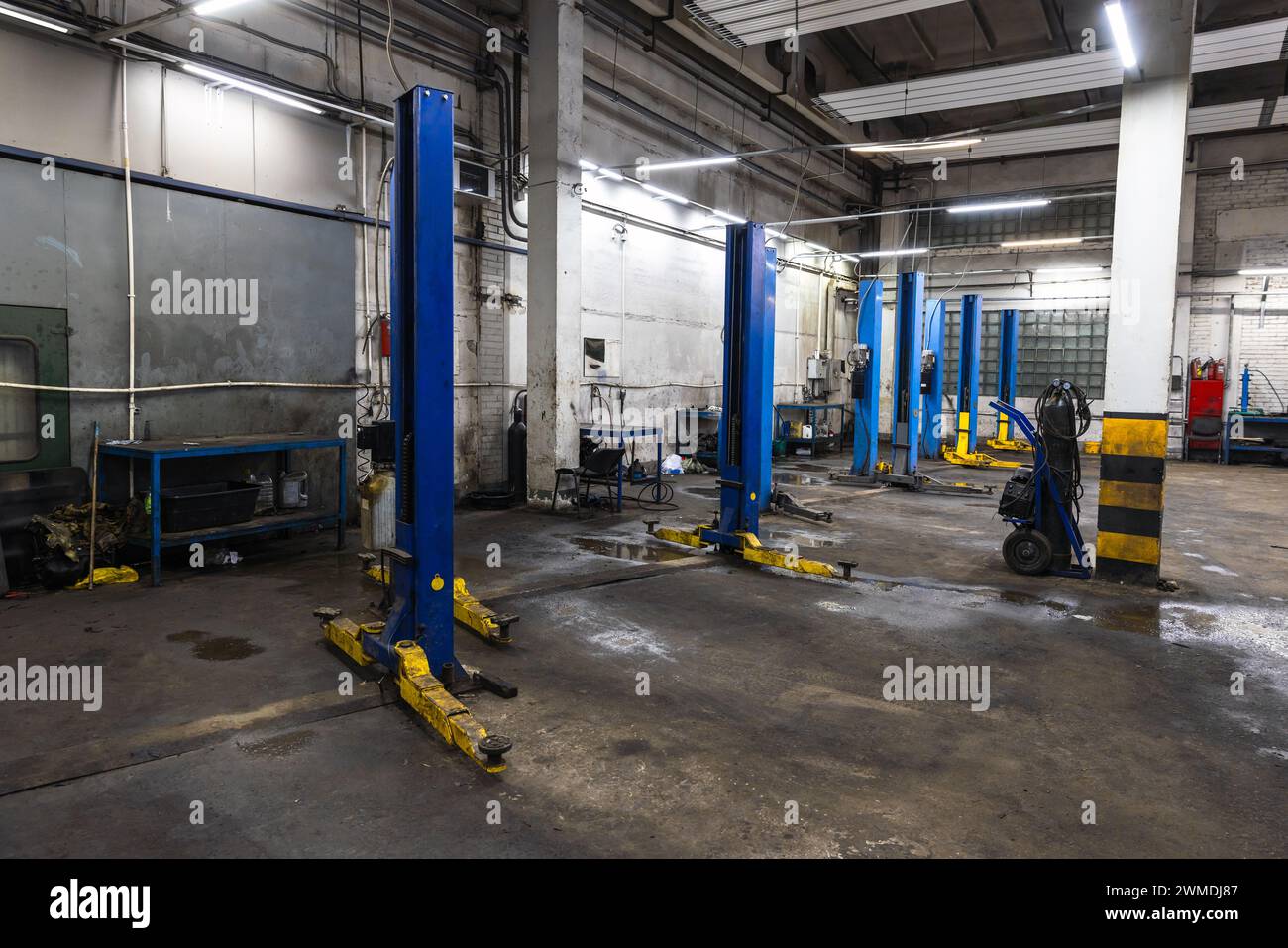 Empty concrete car service interior with blue yellow car lifts Stock ...