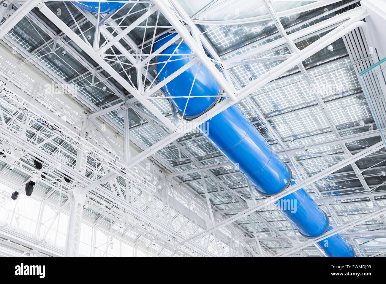 White industrial interior with ceiling steel framework and blue vent ...
