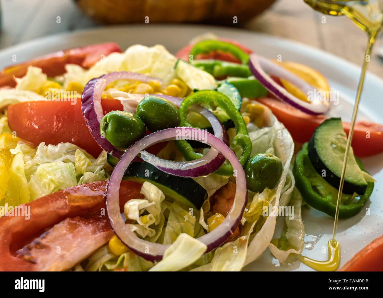 Vibrant salad highlighted with the golden touch of the oil Stock Photo ...