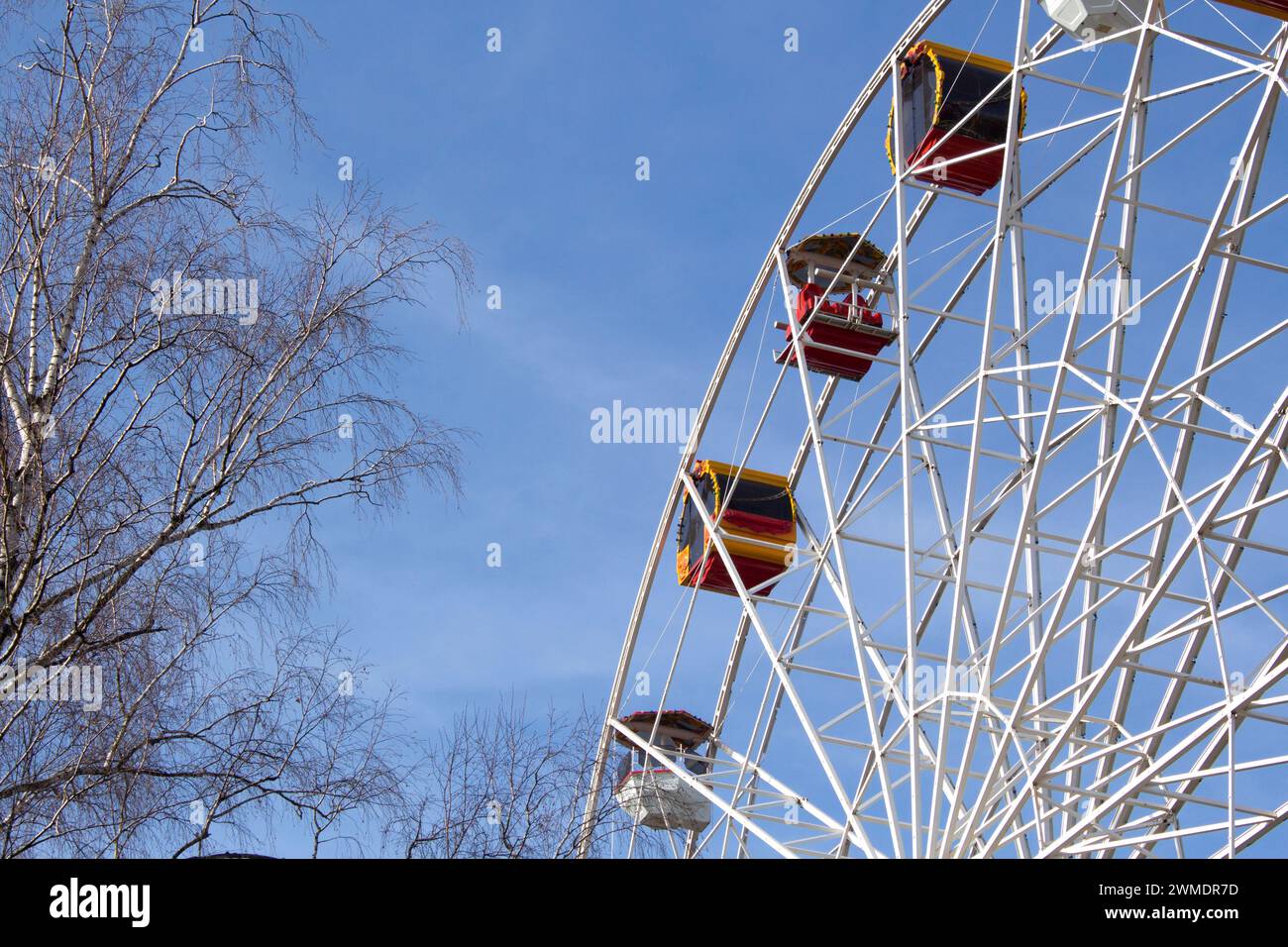 Ferris wheel featuring colourful seating pods against backdrop of blue ...