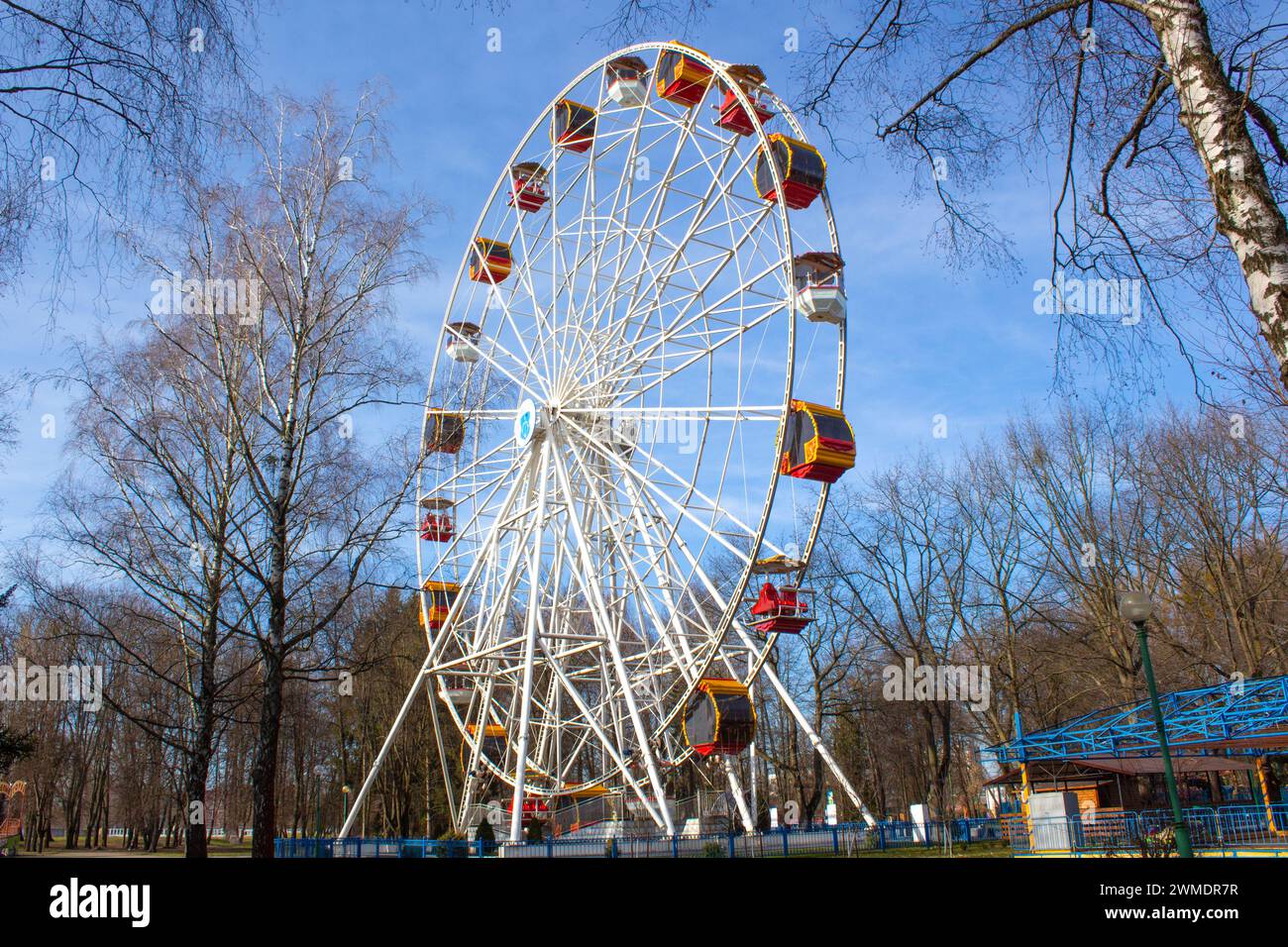 Ferris wheel featuring colourful seating pods against backdrop of blue ...