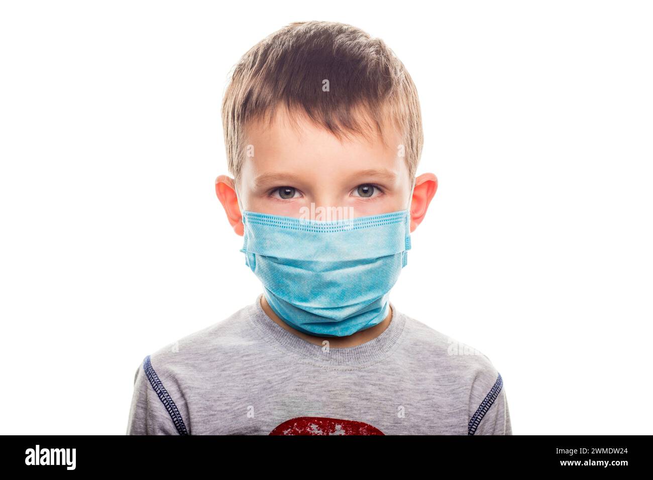 Little boy in a disposable mask on a light background. Kid is wearing ...