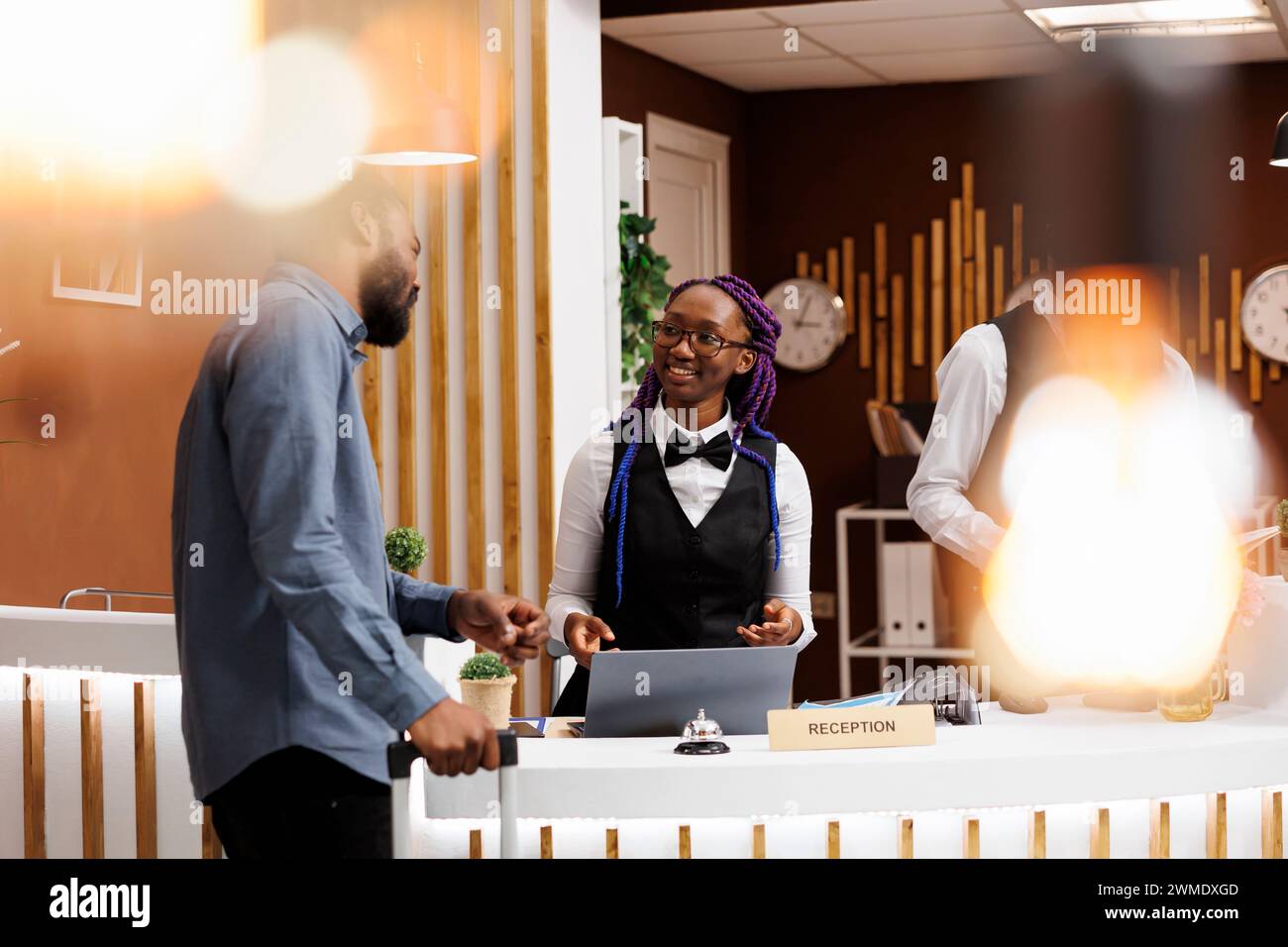Smiling friendly African American woman receptionist talking with man ...
