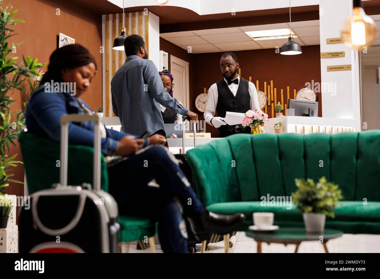 Hotel front office team welcoming and registering guest at reception ...
