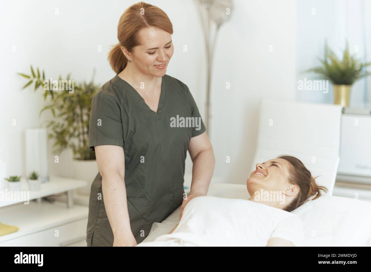 Healthcare time. happy massage therapist woman in massage cabinet with ...
