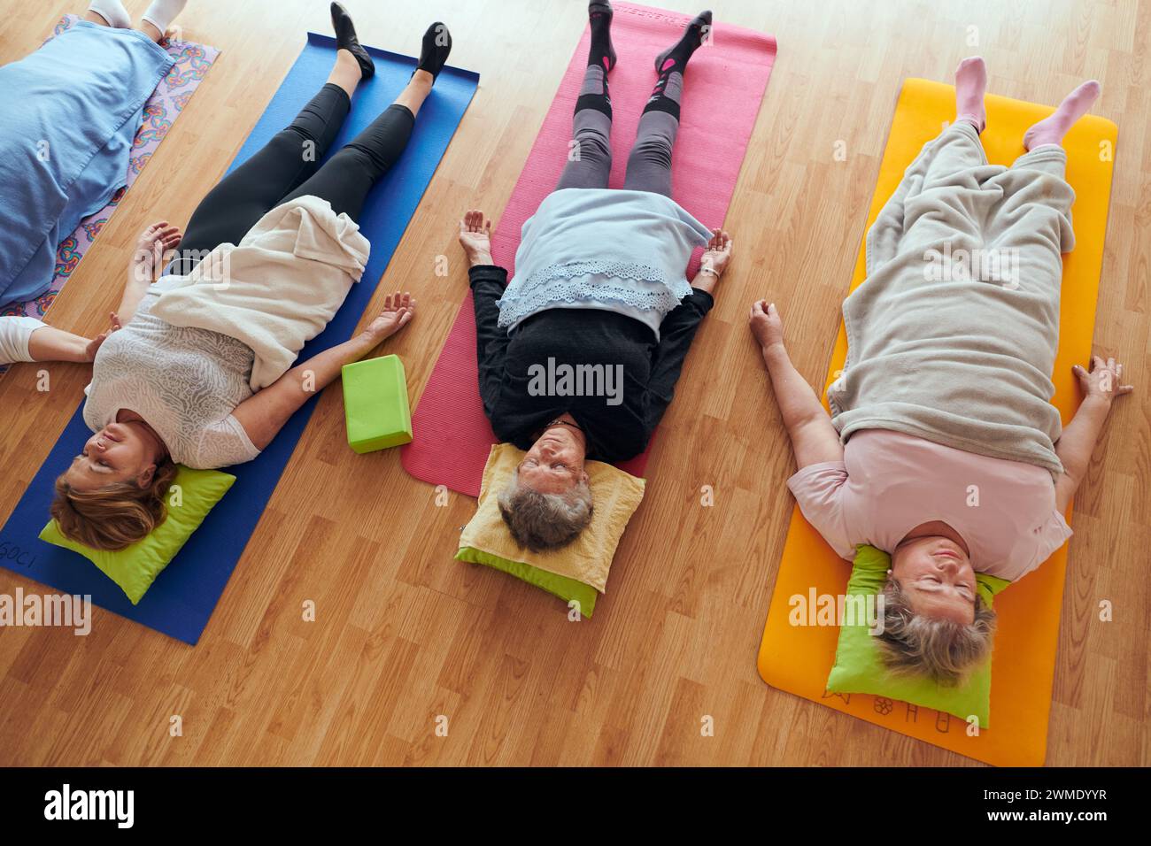 Top view of group of senior women engage in various yoga exercises ...