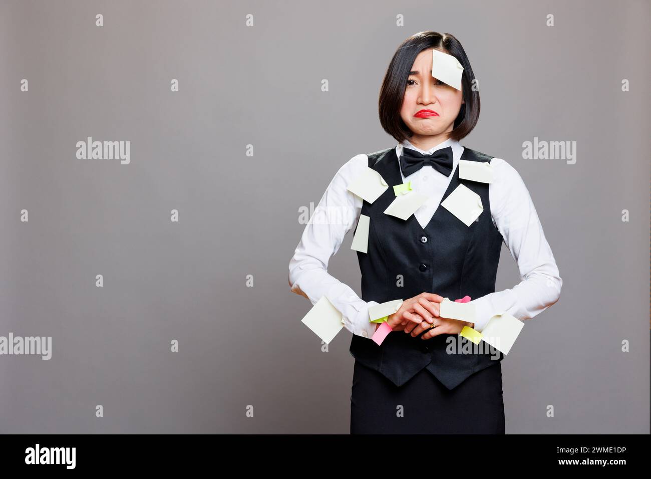 Depressed asian waitress in uniform stressed with workload looking at ...