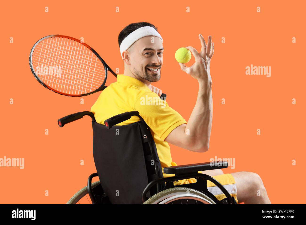 Tennis player in wheelchair with racket and ball on orange background ...