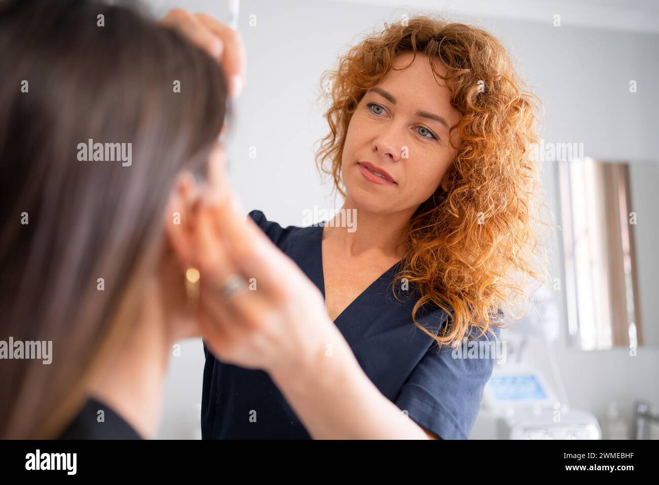 Female dermatologist performing procedure on woman customer ...