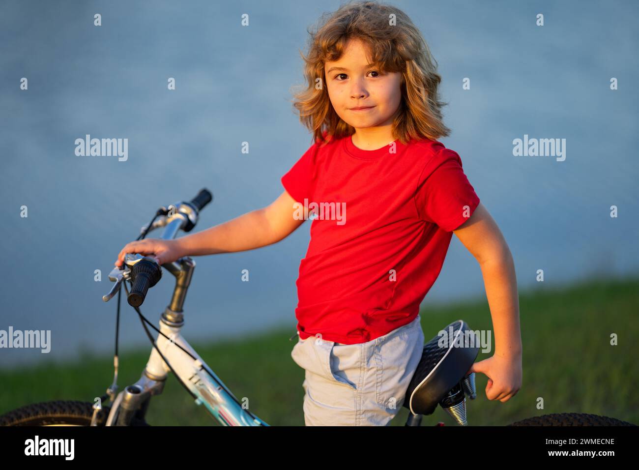 Little kid boy riding a bike in summer park. Child drive a bike on a ...