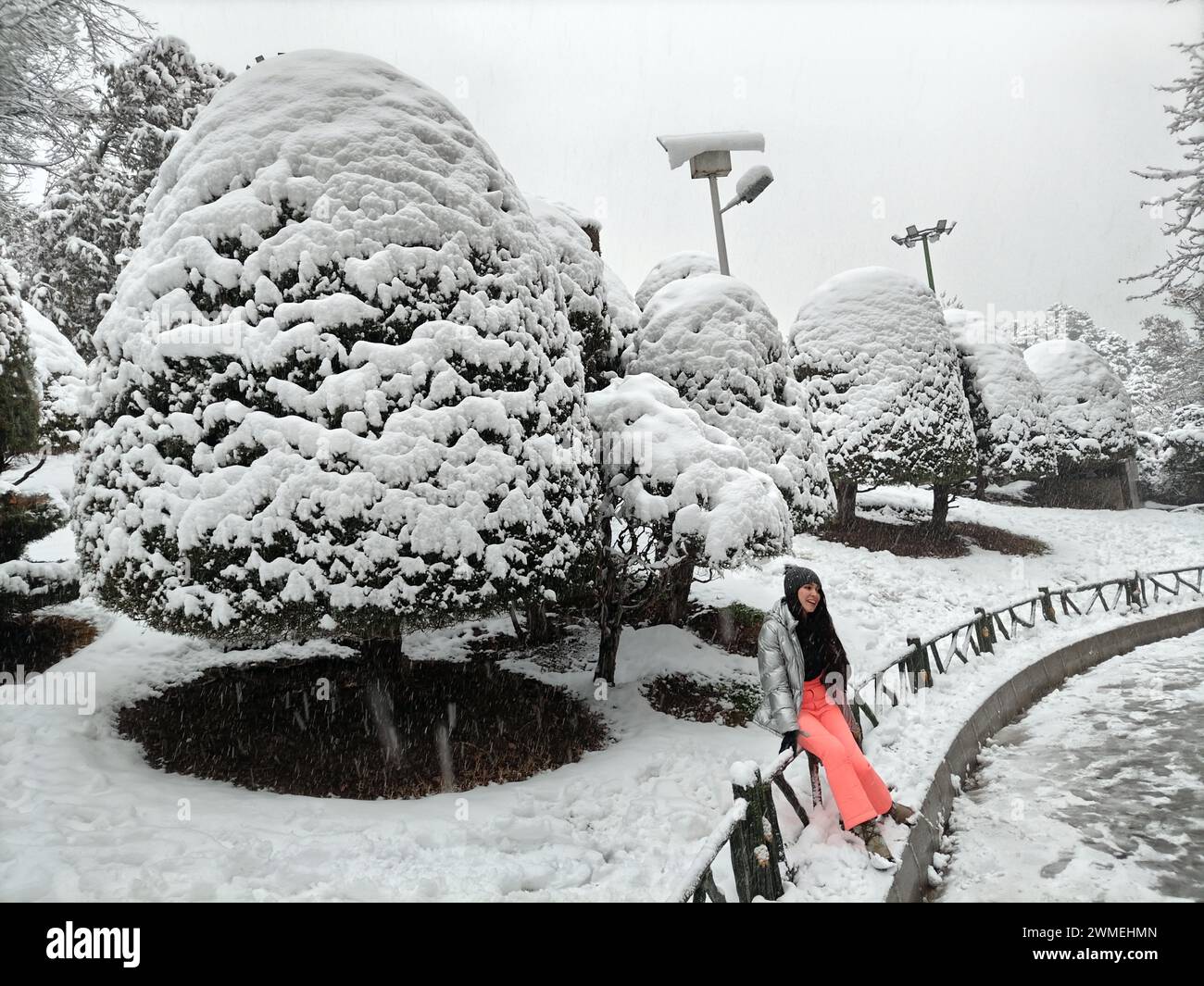 Tehran, Iran. 25th Feb, 2024. A woman takes photo amid snow at a park ...