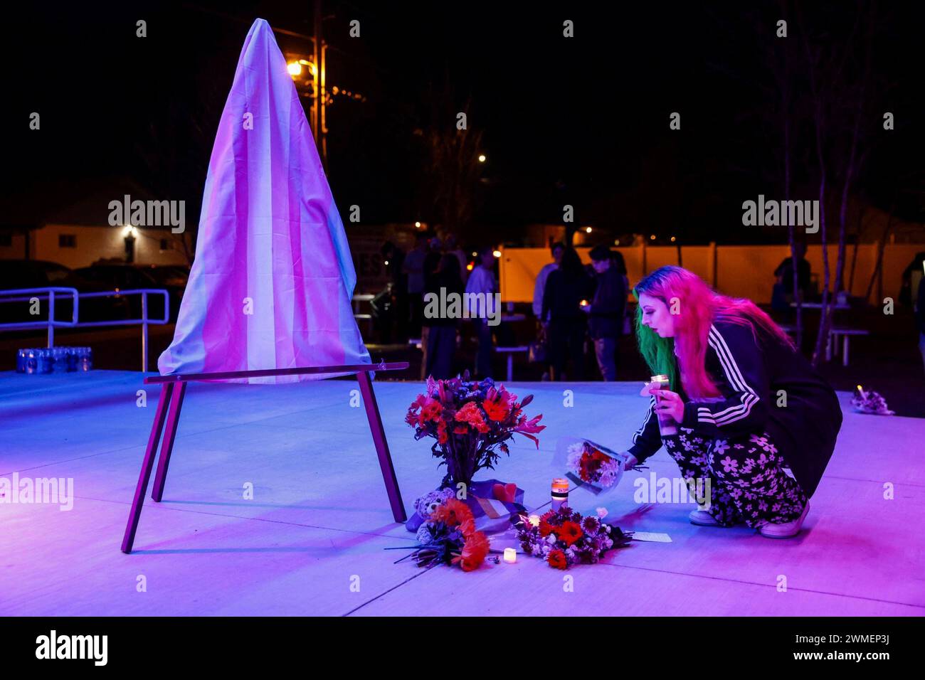 Skylar Boyd places items at a memorial on a stage after a community candlelight vigil for Nex ...