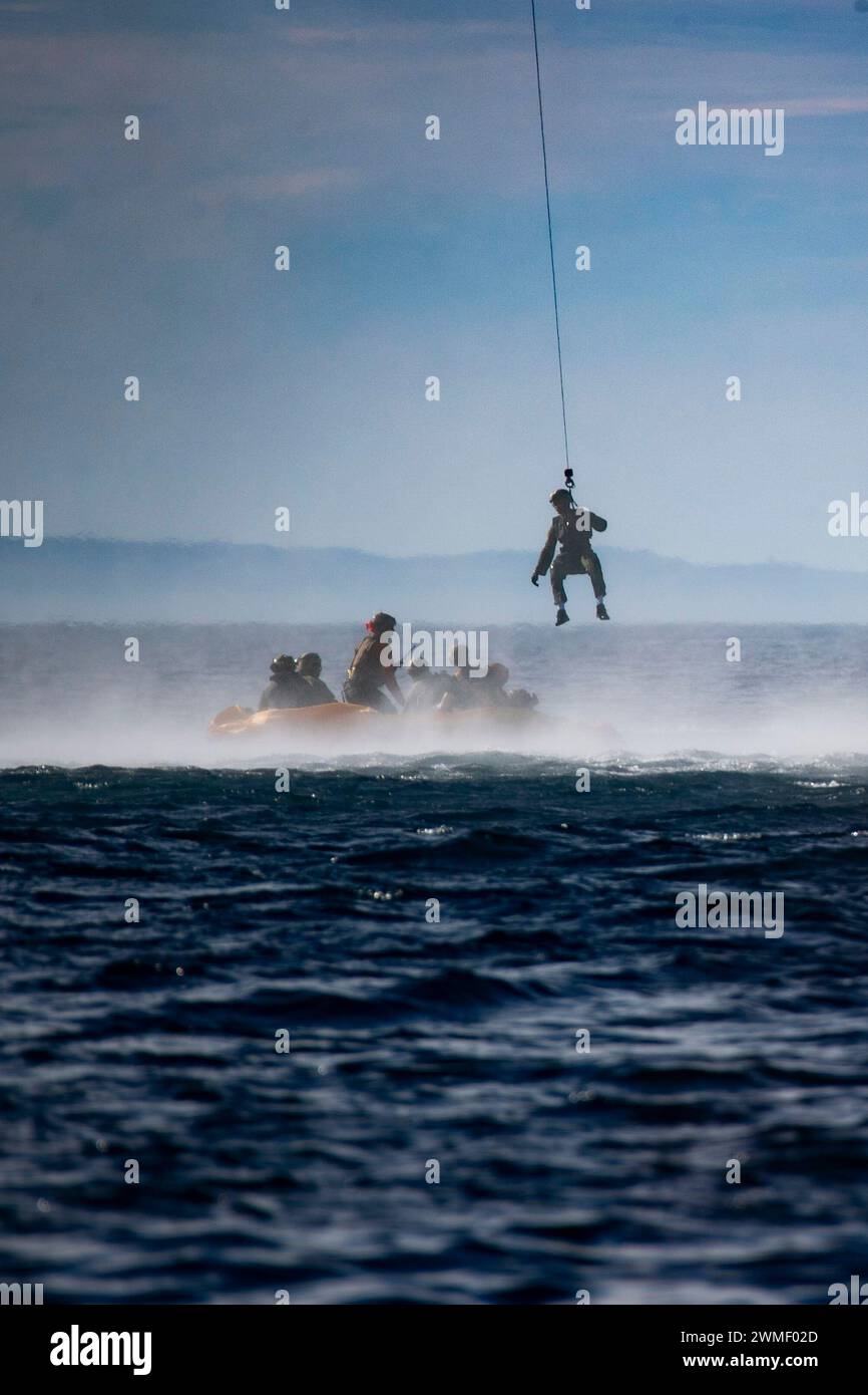 An air rescue swimmer lowers from an MH-60S Seahawk assigned to ...