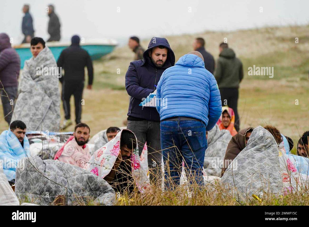 FILE - This Feb. 26, 2023 file photo shows migrants wrapped in blankets ...