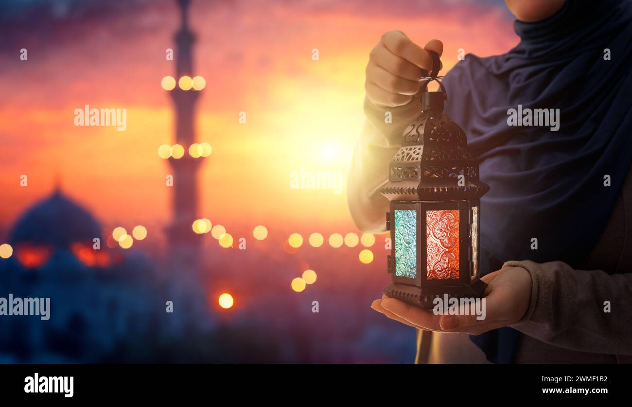 Woman is holding Ornamental Arabic lantern with burning candle glowing ...
