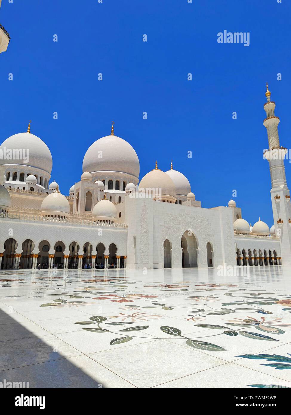A grand building featuring white arches with intricate mosaic design on ...