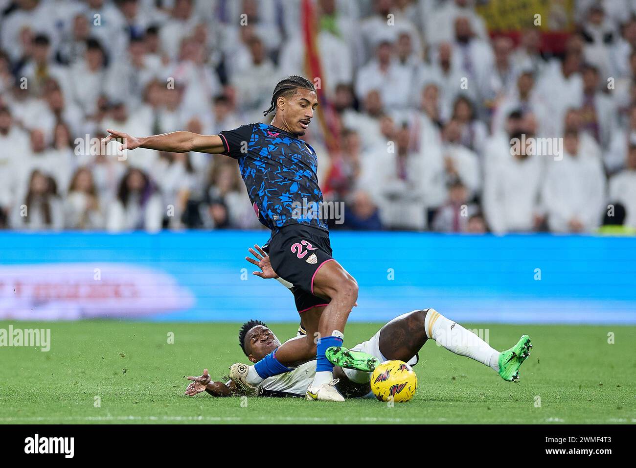 Madrid, Spain. 25th Feb, 2024. Loic Bade of Sevilla FC and Vinicius ...
