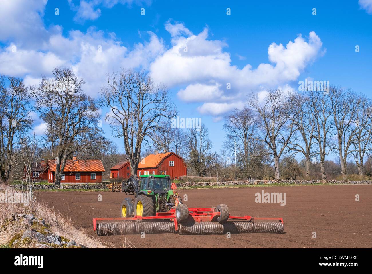 Spring farming with a tractor on a field Stock Photo - Alamy