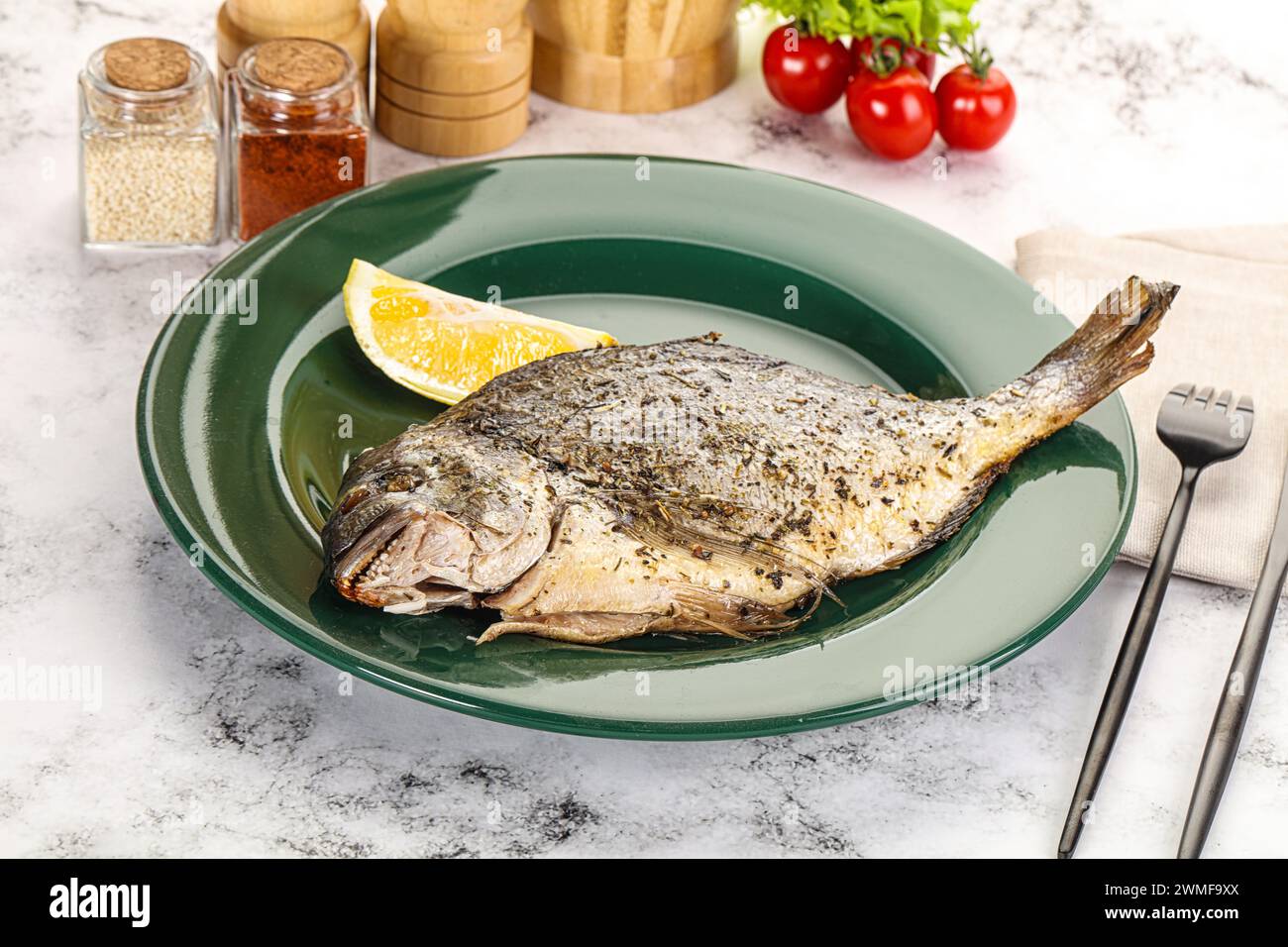 Baked Dorado fish served lemon slice Stock Photo - Alamy