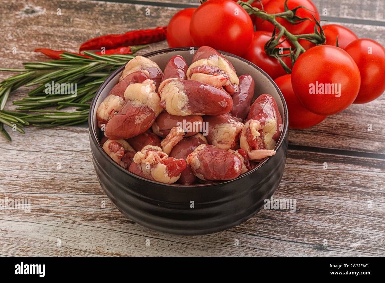 Raw chicken hearts for cooking served rosemary Stock Photo - Alamy