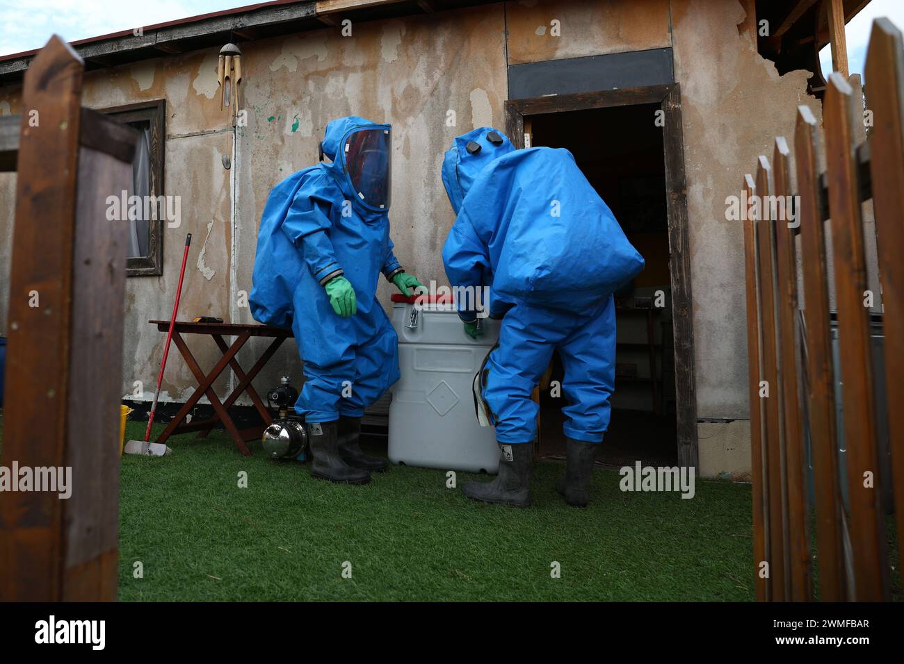 People wear blue Personal protective equipment (PPE) with gas mask for ...