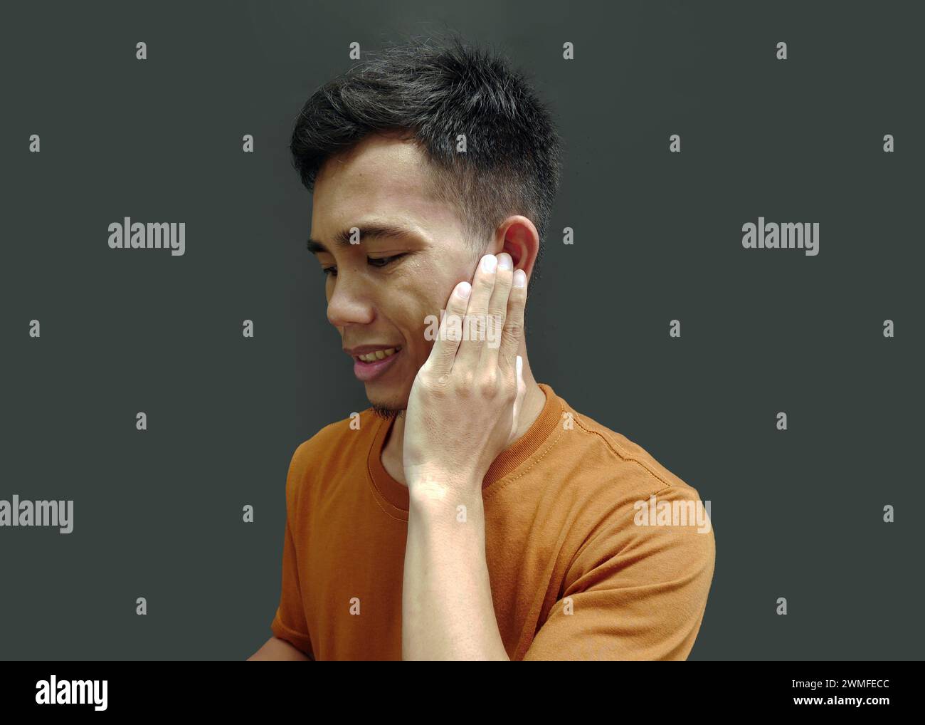 Grimacing young man having severe toothache, holding his cheek with hand, face in pain, isolated ...