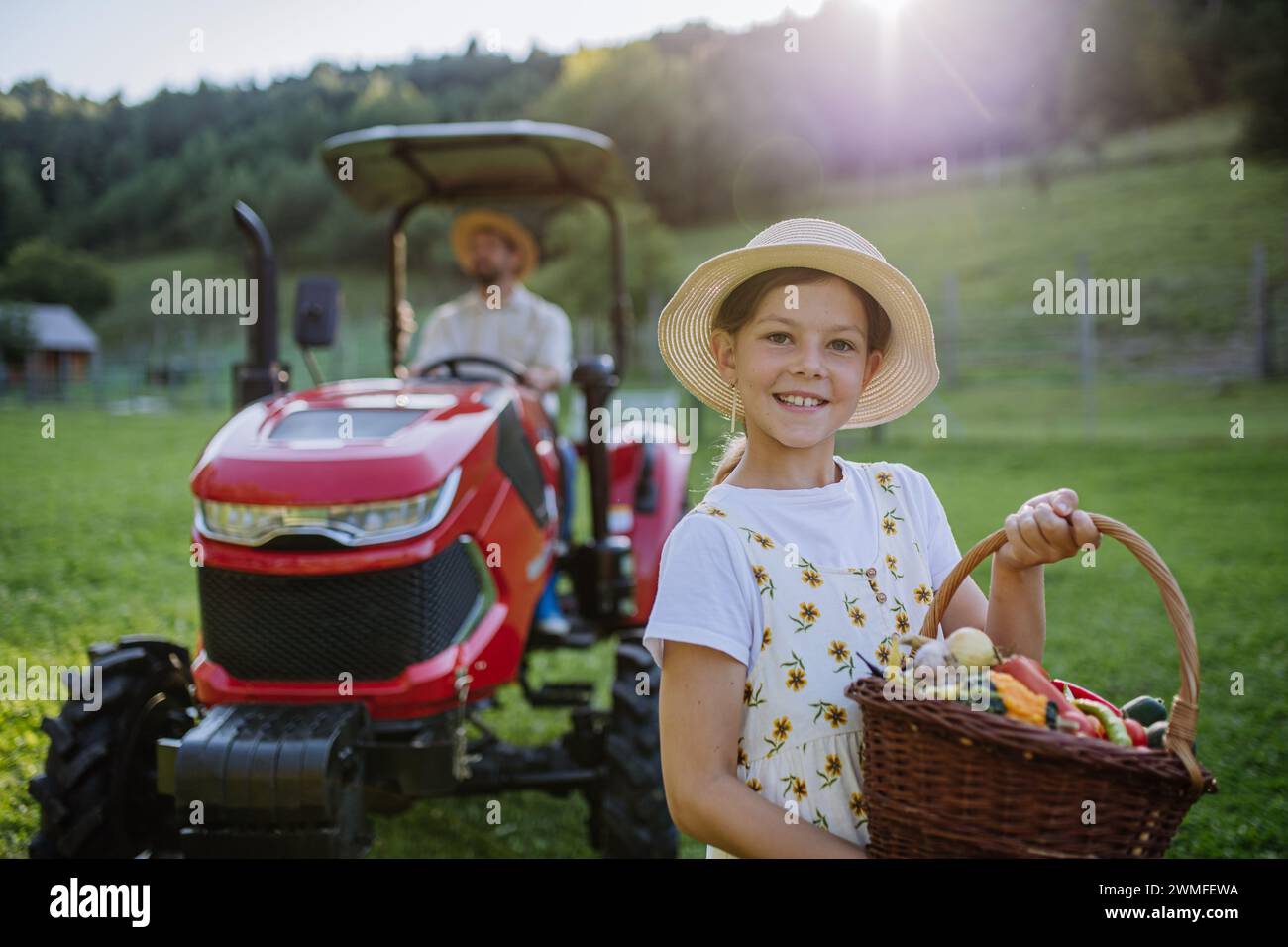 Girl on farm holding harvest basket full of fresh vegetables ...