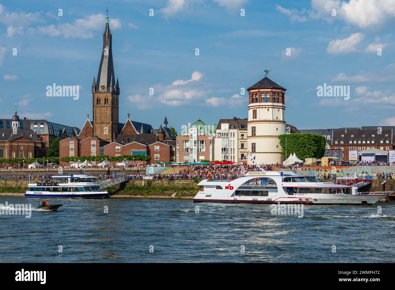 A busy stretch of river with boats and a crowd of people against the ...