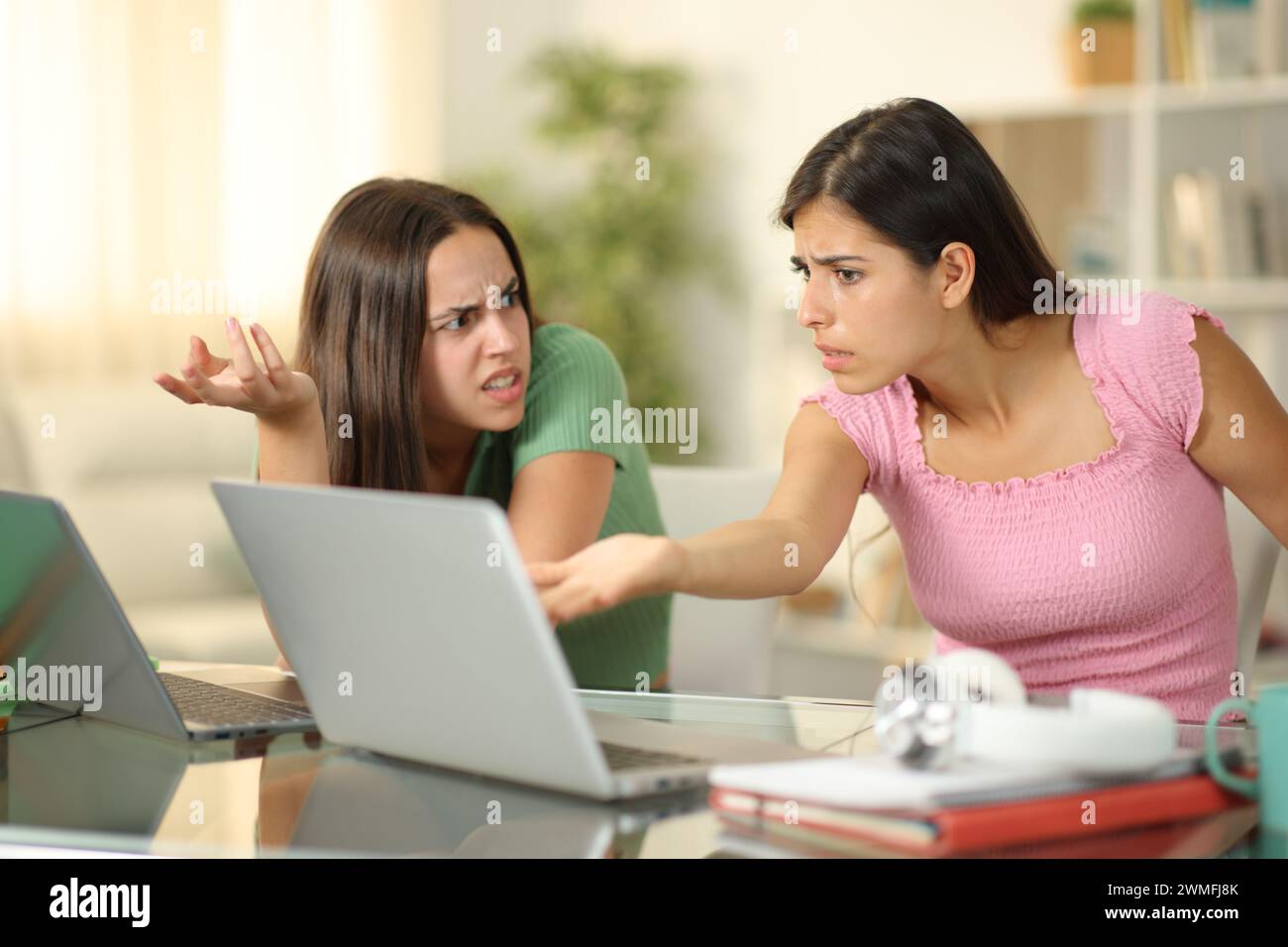 Two angry students arguing studying online with laptops at home Stock ...